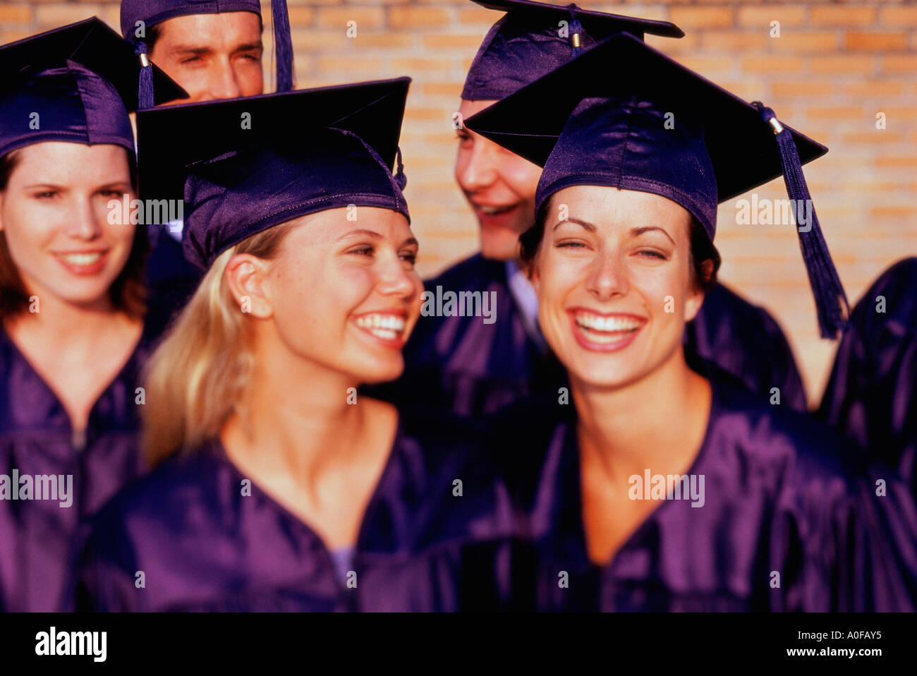 Three female graduates and two male graduates smiling Stock Photo - Alamy
