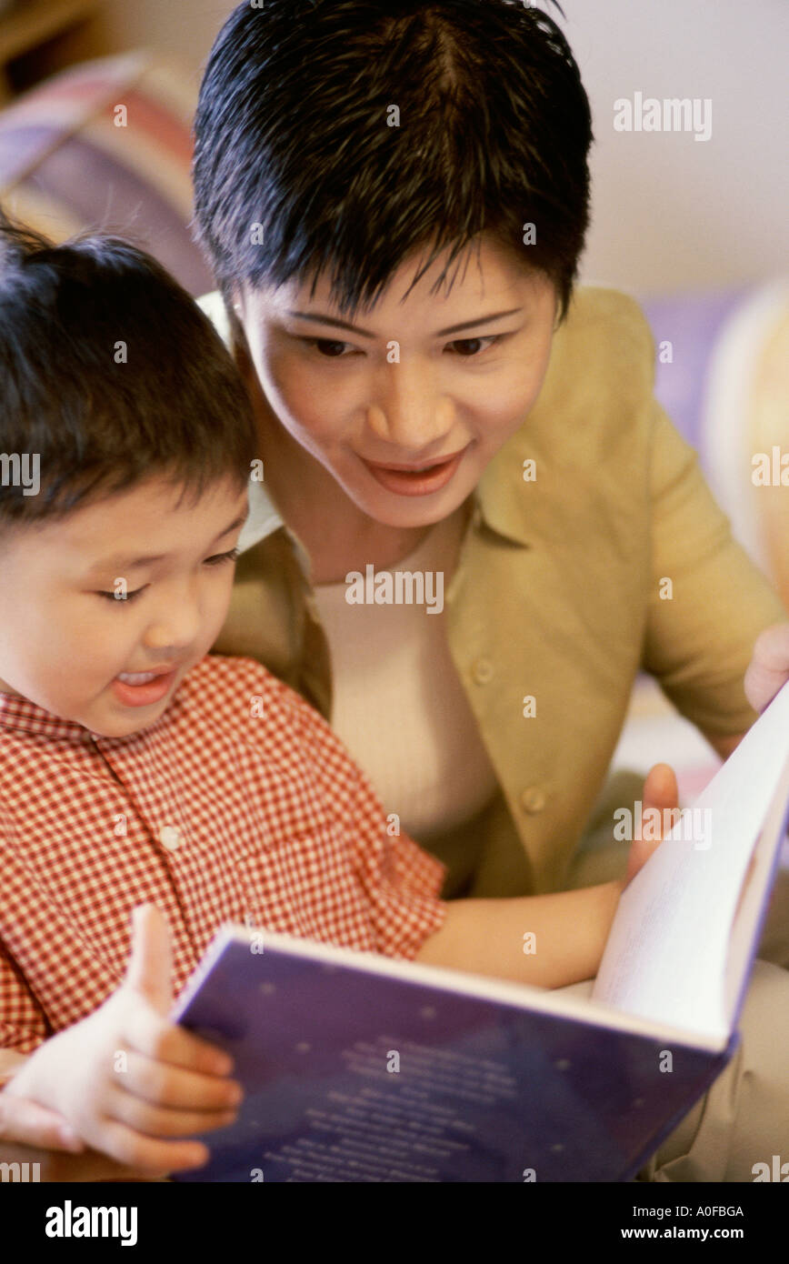 Mother reading a book with her son Stock Photo - Alamy