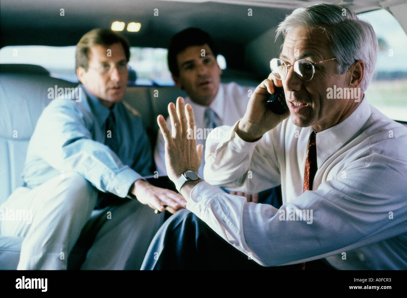 Three businessmen sitting in a car Stock Photo - Alamy