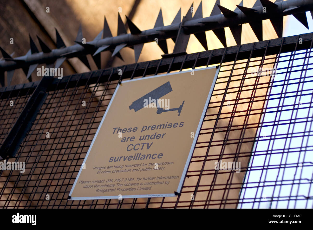 Surveillance camera warning sign on protected gate Stock Photo - Alamy