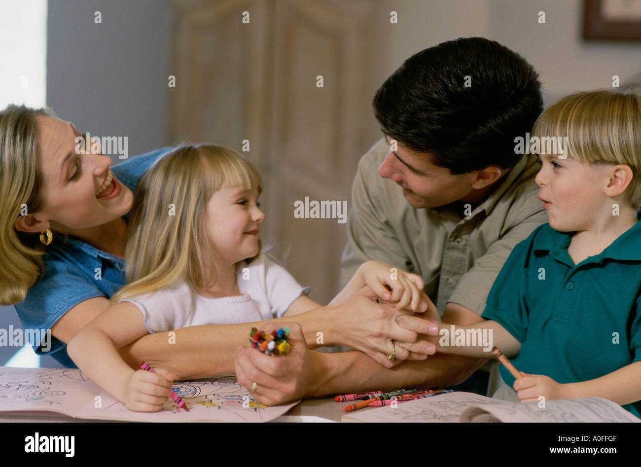 Parents and their children with coloring books Stock Photo - Alamy