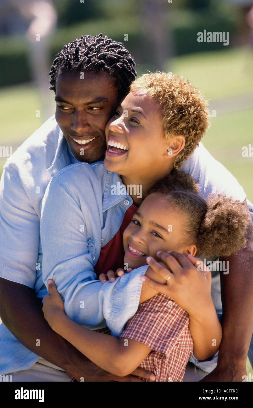 Parents hugging their daughter Stock Photo - Alamy
