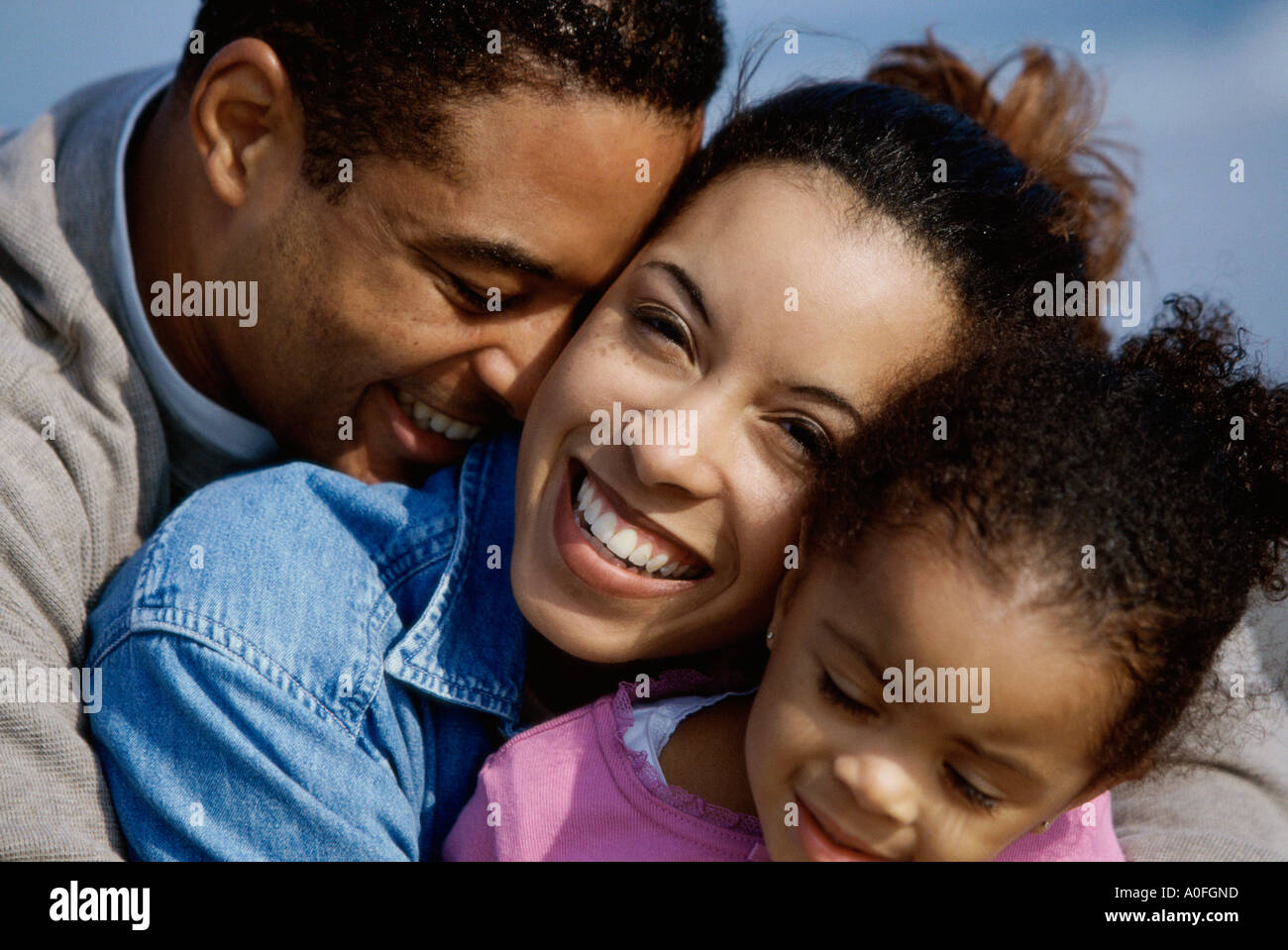 Close-up of parents hugging their daughter Stock Photo - Alamy