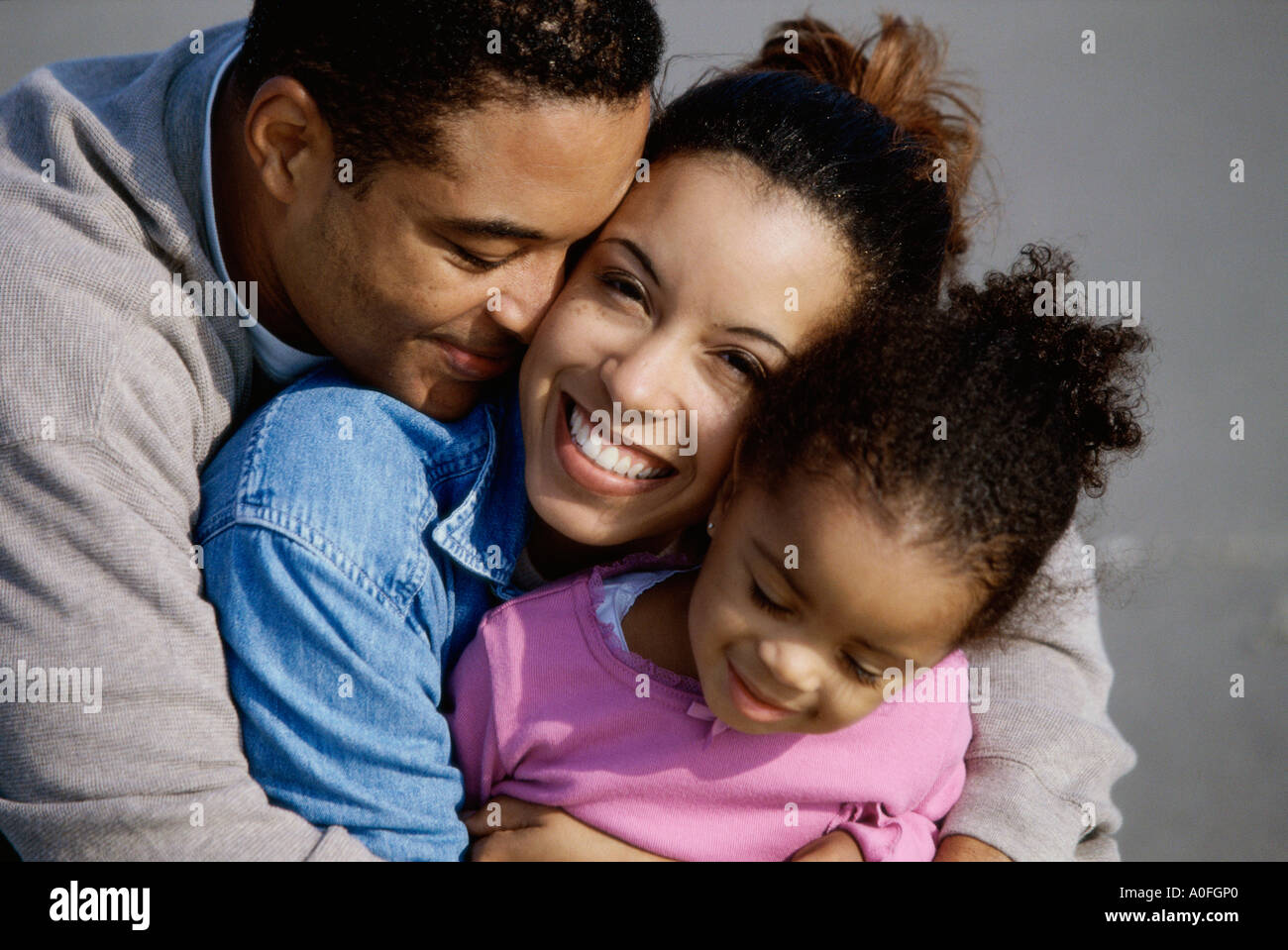 Close-up of parents hugging their daughter Stock Photo - Alamy