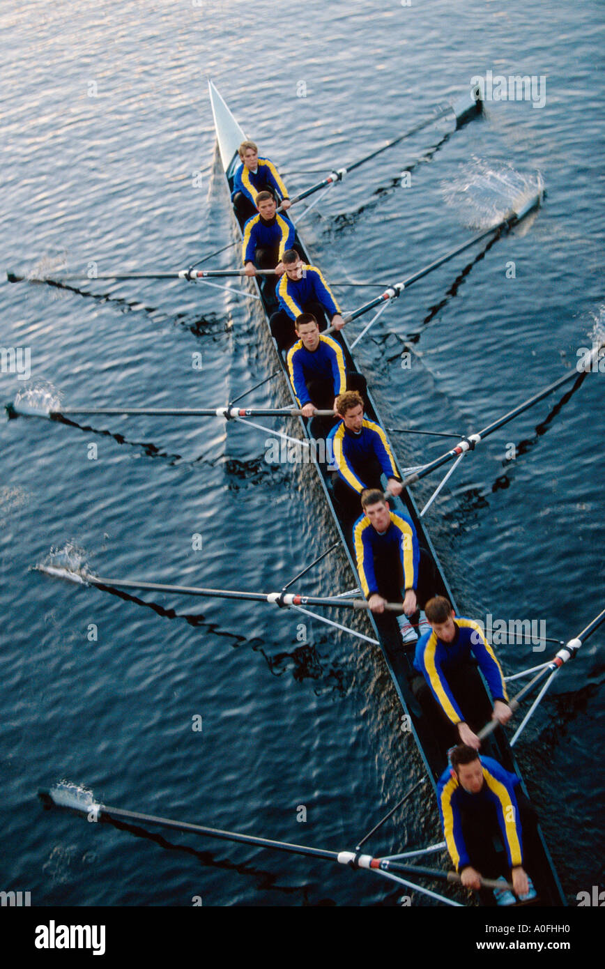 Team of young men rowing a boat Stock Photo - Alamy