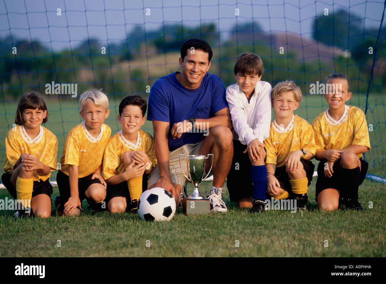 Portrait of a soccer team and coach with a trophy Stock Photo - Alamy