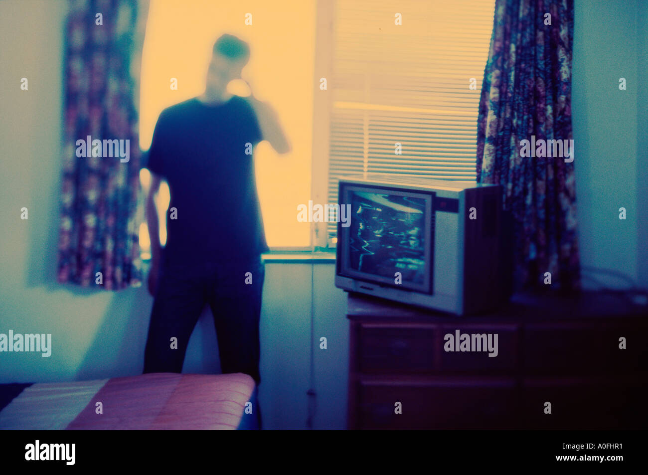 Young man standing beside a television Stock Photo - Alamy
