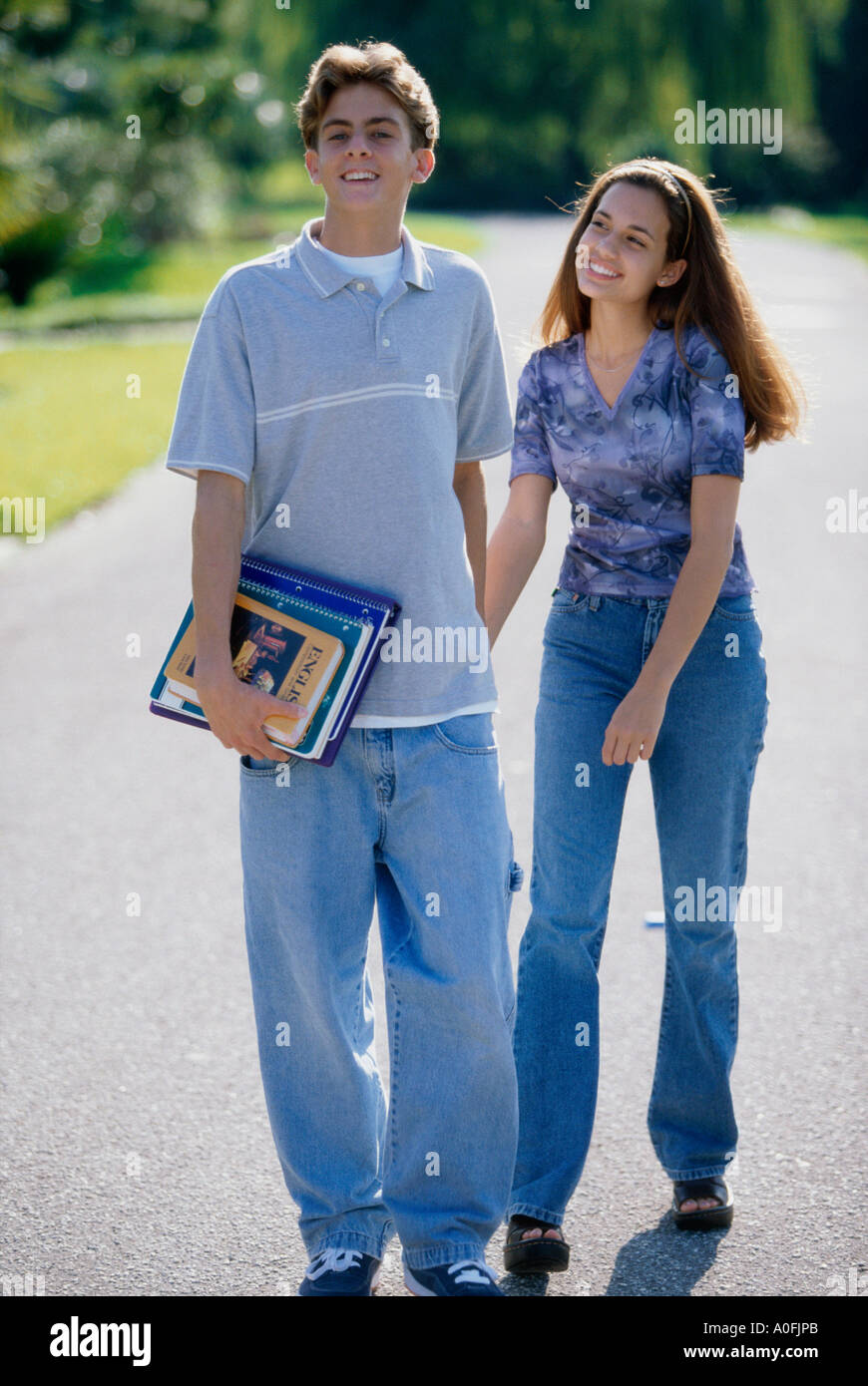 Teenage couple holding hands while walking outdoors Stock Photo - Alamy