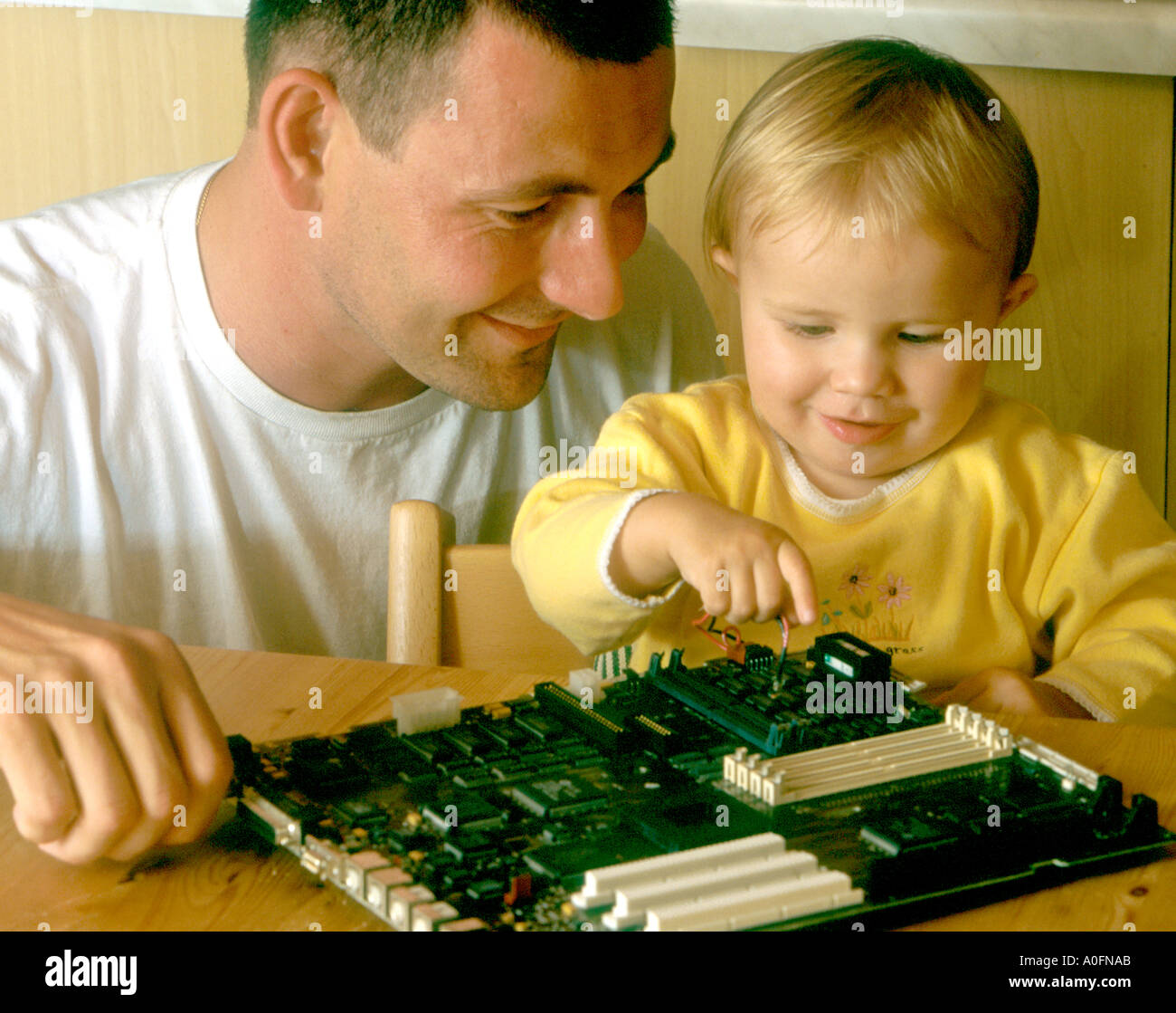 Father and daughter play with a computer Mother board Stock Photo - Alamy