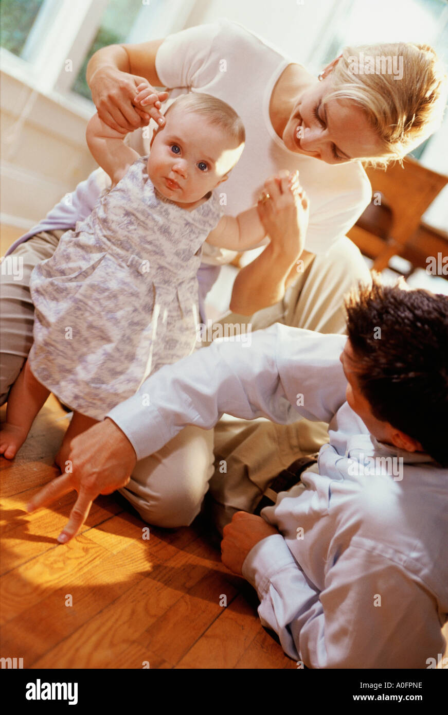 Parents helping their baby girl learn how to walk Stock Photo - Alamy