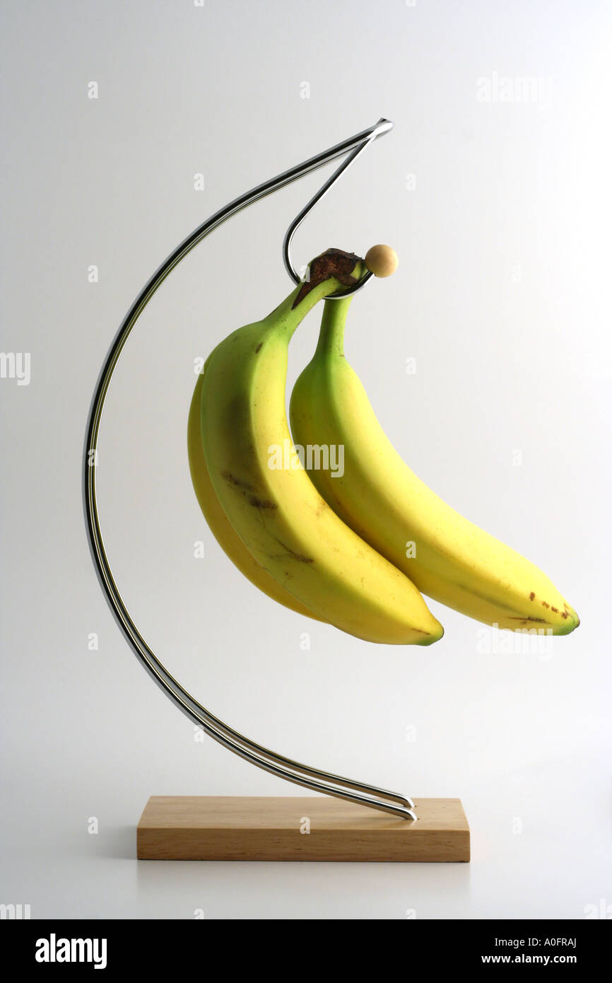 Three bananas on a curved banana stand Stock Photo - Alamy
