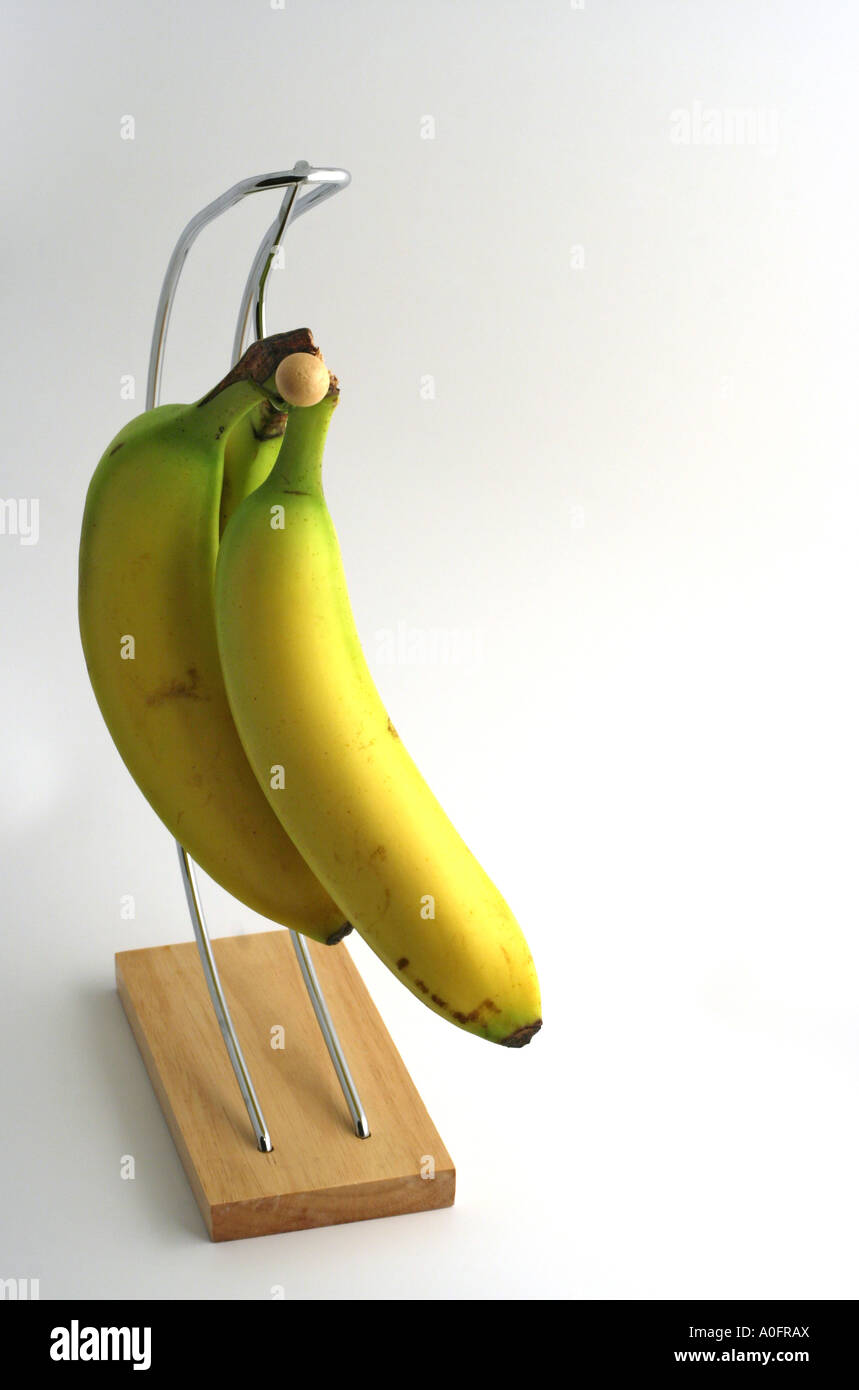 Three bananas on a curved banana stand Stock Photo - Alamy