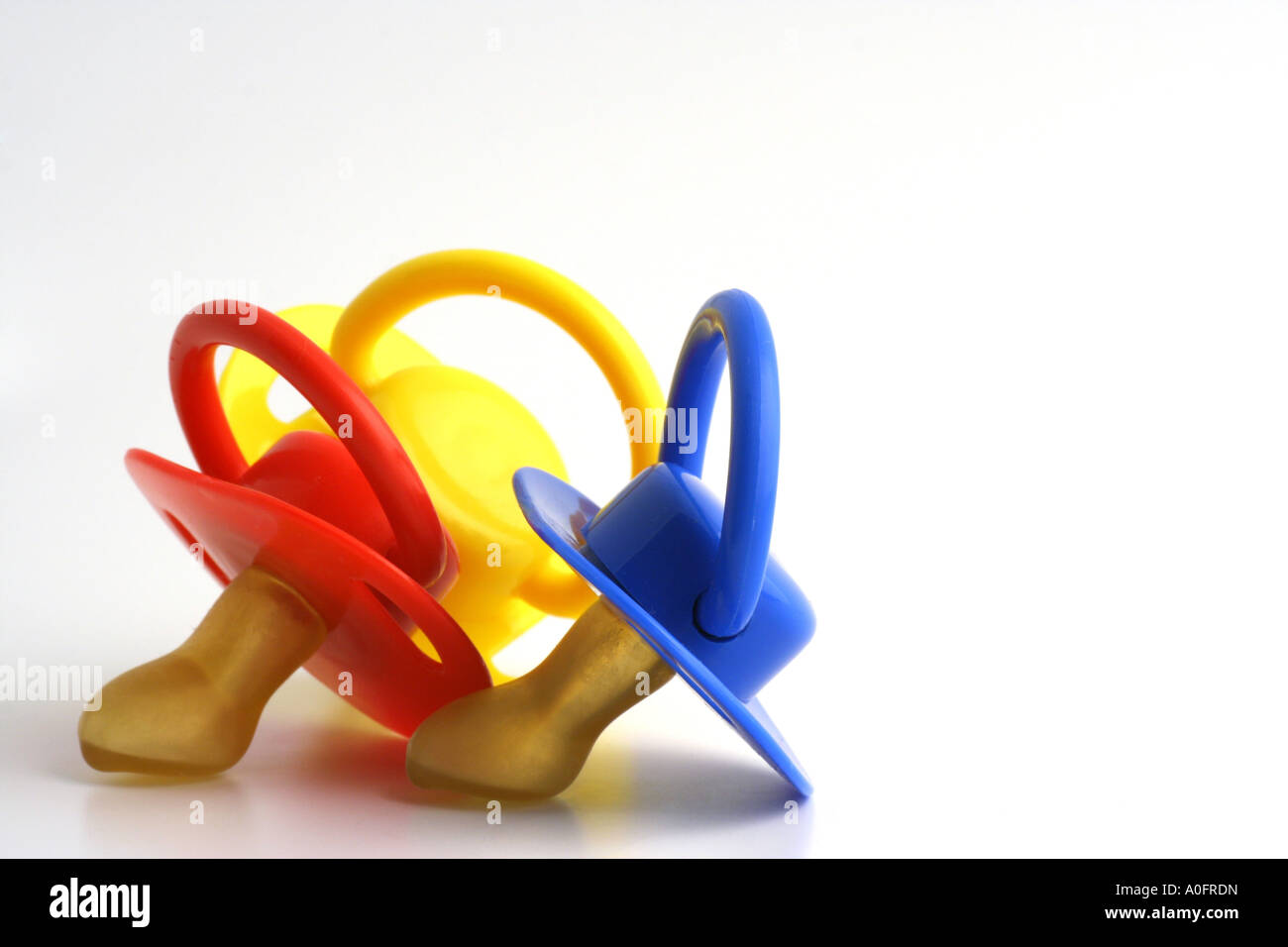 Red blue and yellow baby pacifiers Stock Photo - Alamy