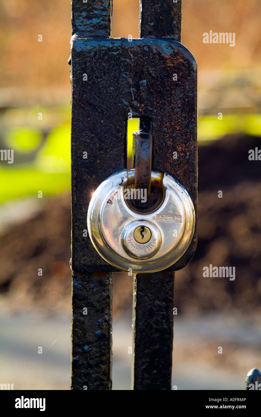 Padlock fastened on metal gate Stock Photo - Alamy