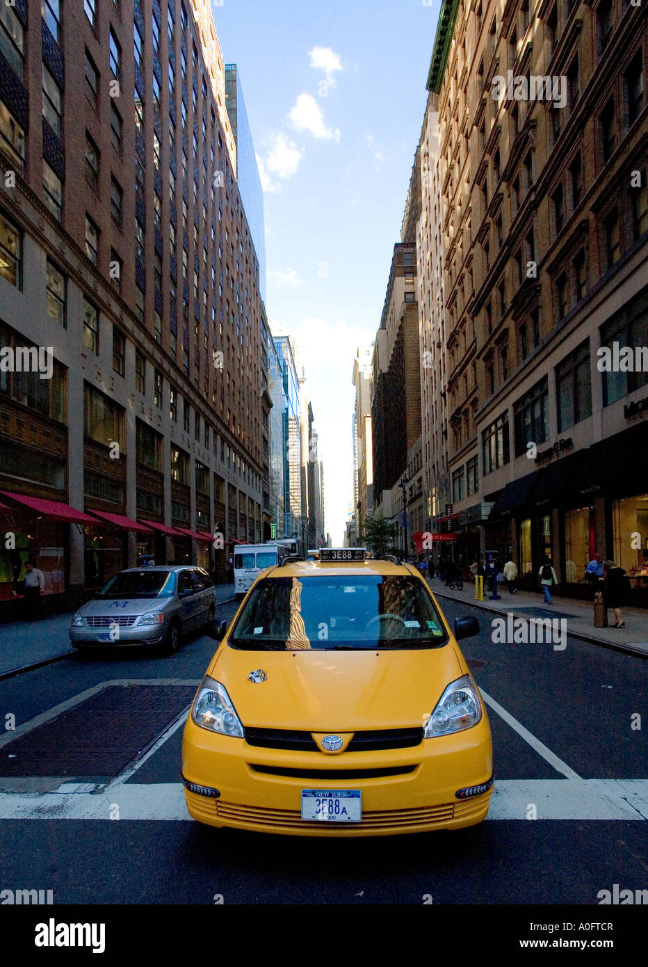 yellow taxi cab between building row Stock Photo - Alamy