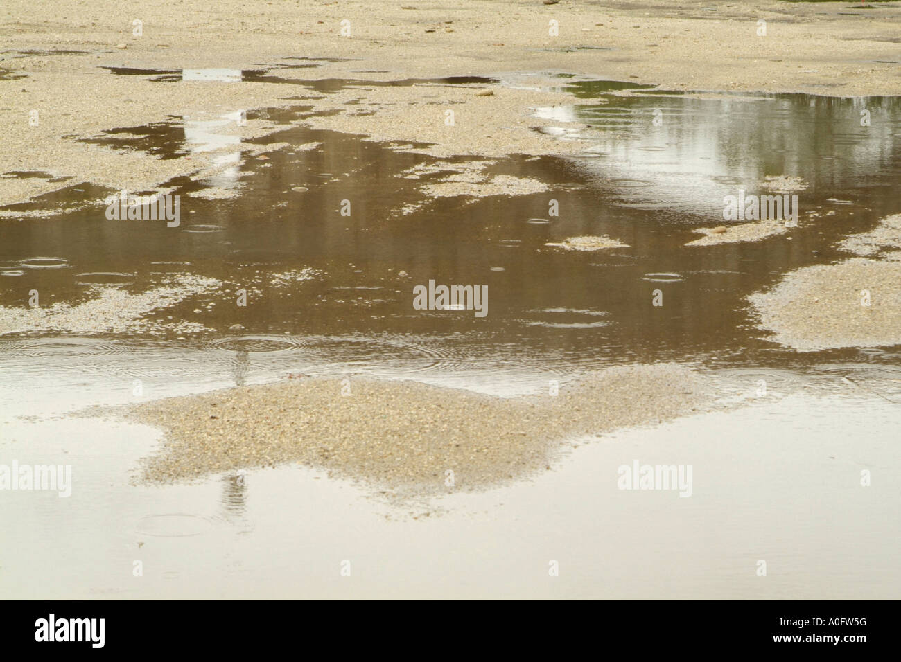 water puddle in a sandy pavement Stock Photo - Alamy