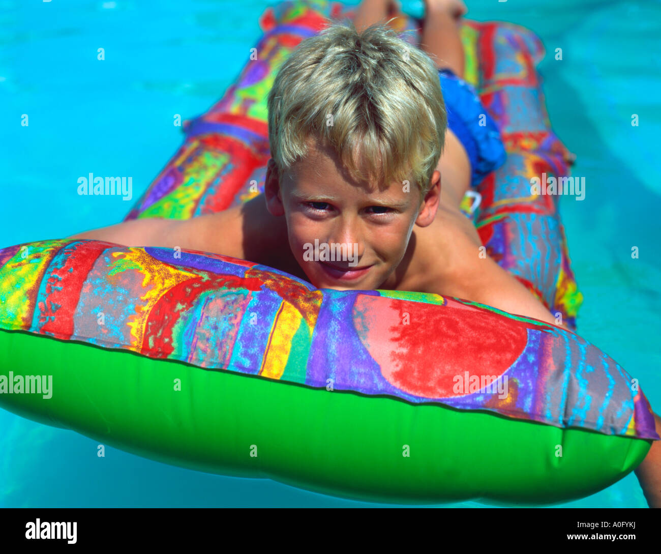 Young boy floating on an airbed in a swimming pool Stock Photo - Alamy