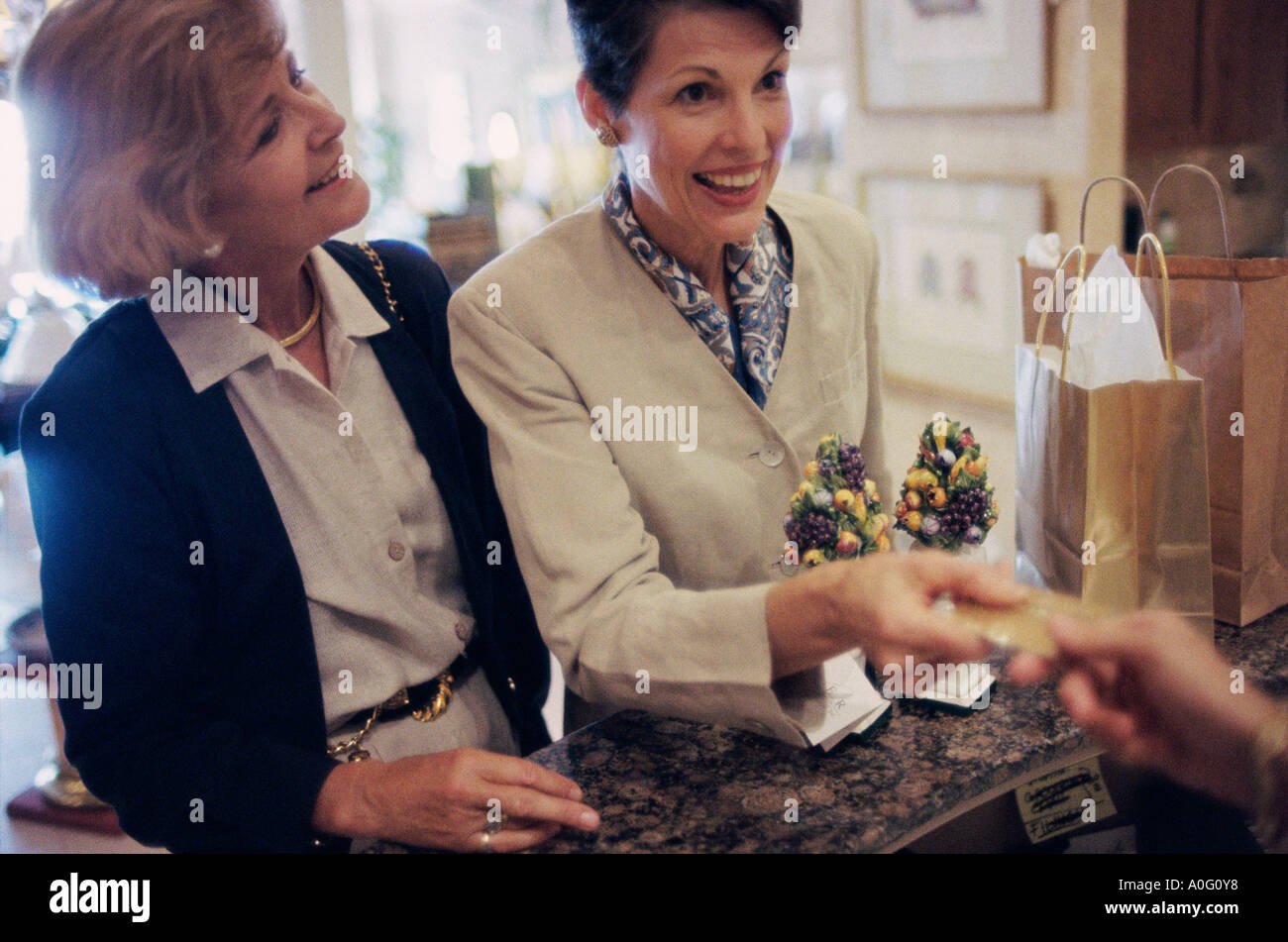 Two mature women at a store counter Stock Photo - Alamy