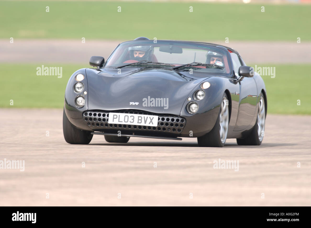 black tvr tuscan convertible sports car racing around a circuit in the ...