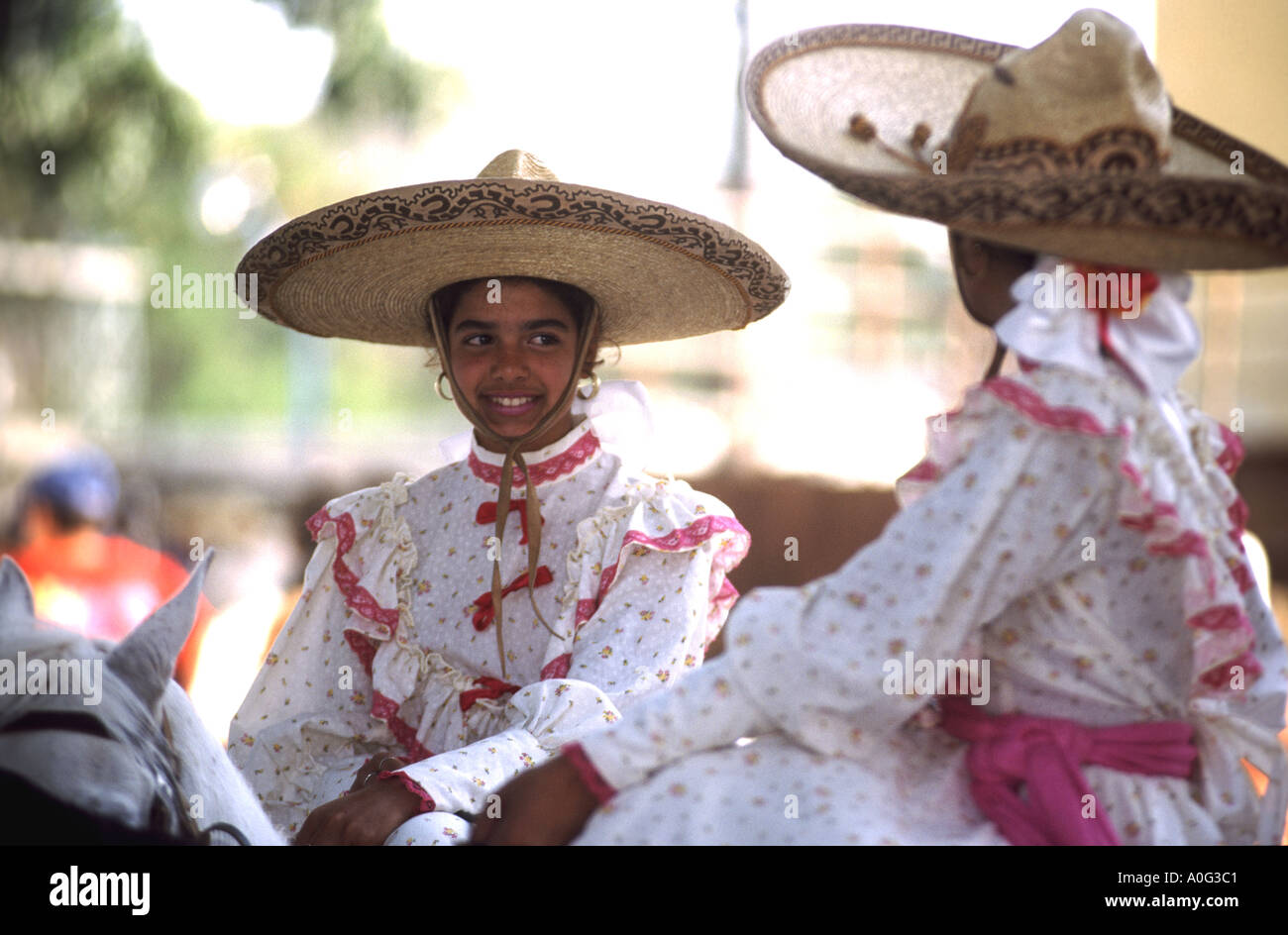 Pretty young smiling Cuban girl with sombrero and colorful dress ...