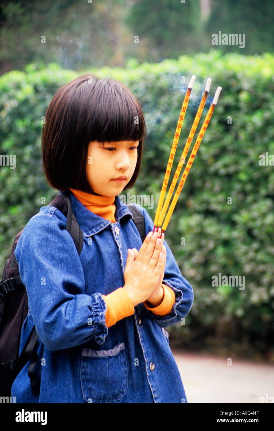 Shijiazhuang, Hebei, China - Girl praying with burning joss sticks at ...