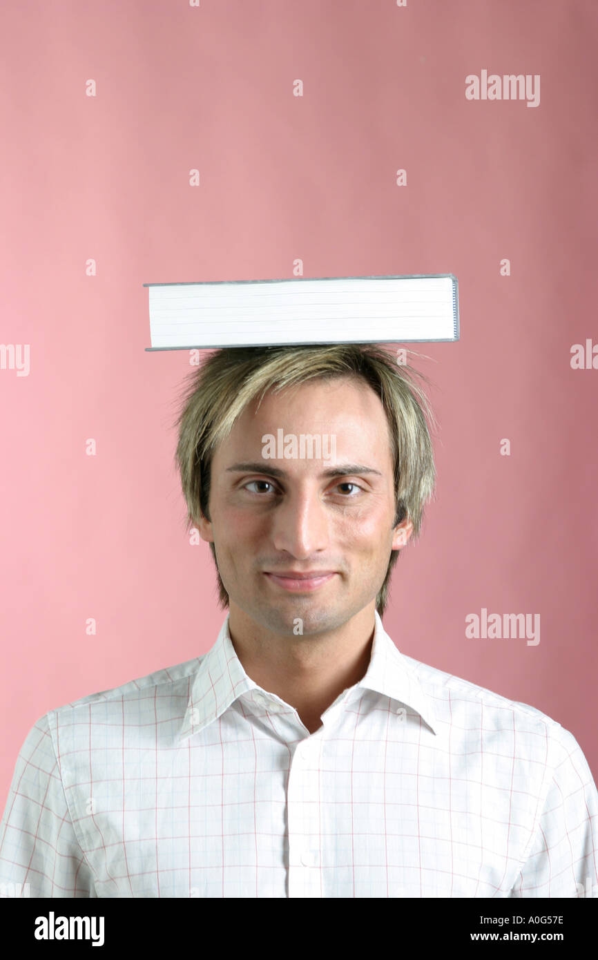 Young man with a book balanced on his head Stock Photo - Alamy