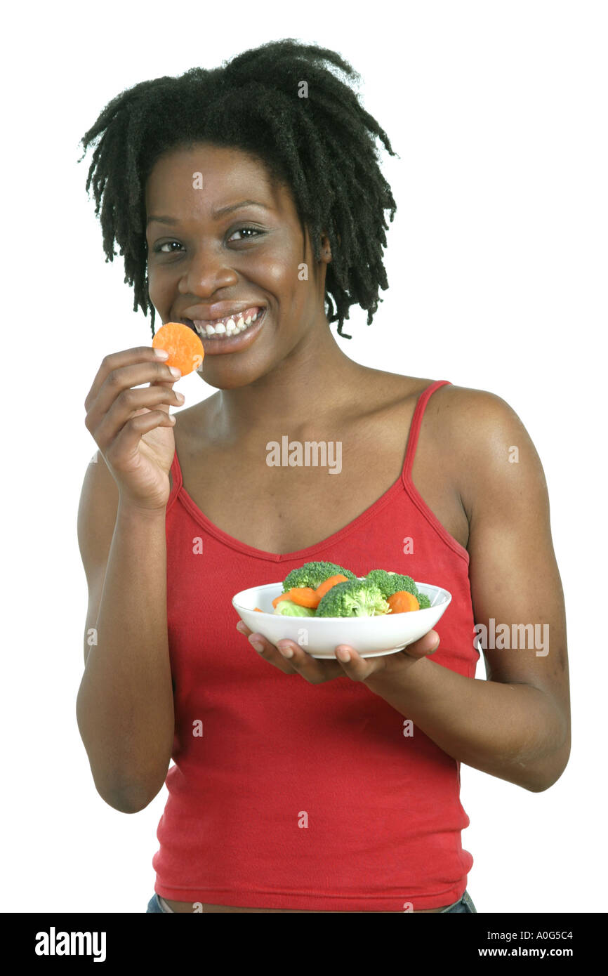 Black woman eating fresh vegetables Stock Photo - Alamy