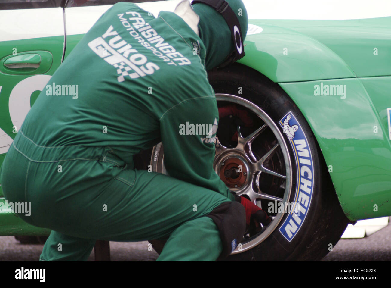 race car tyres being fitted during pit stop quick change team work ...