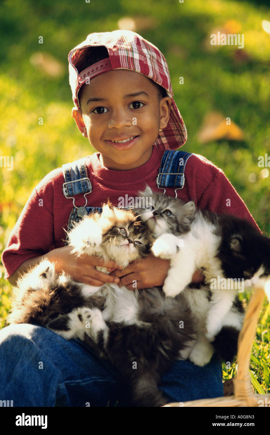 Portrait of a boy holding cats Stock Photo - Alamy