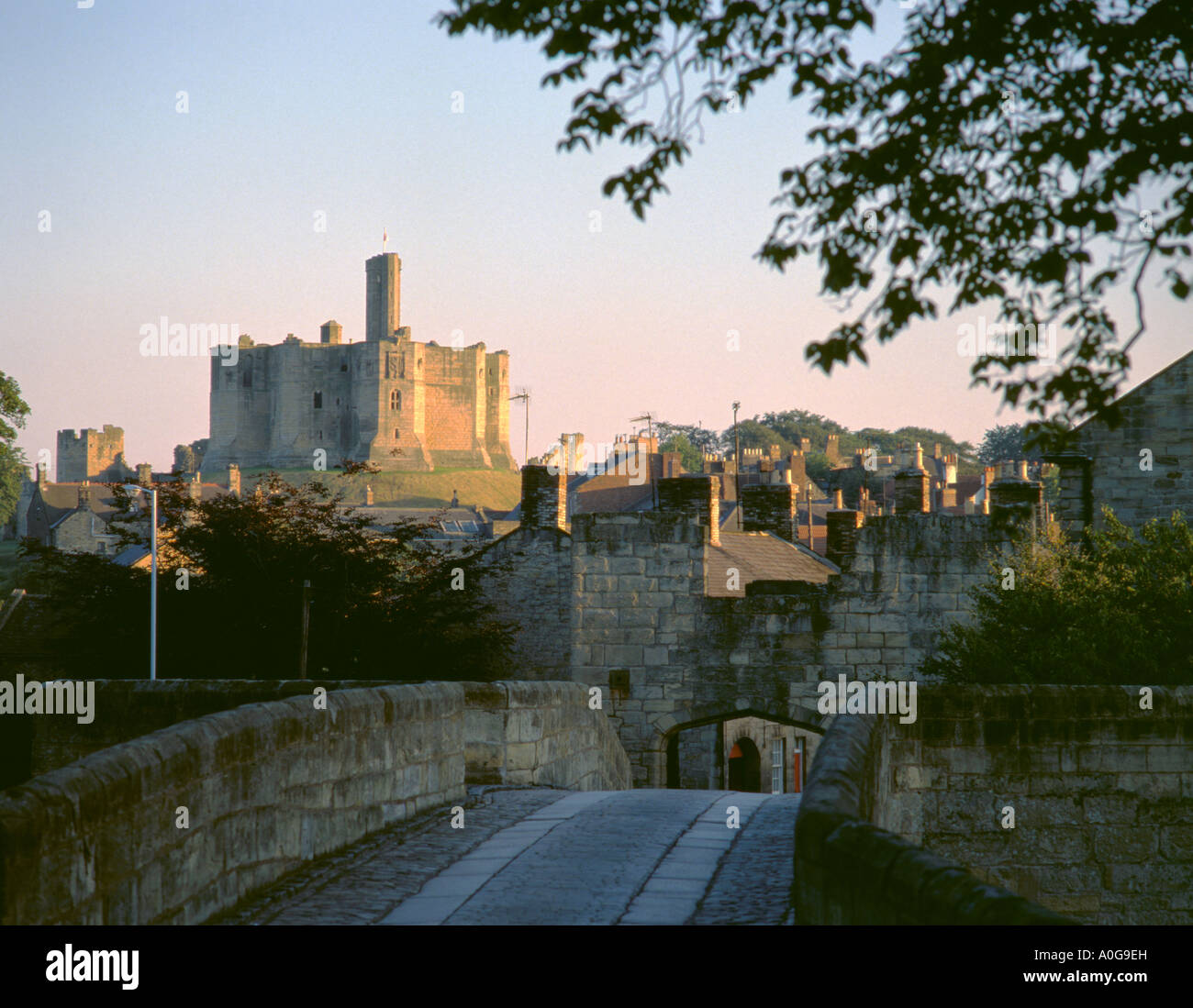 Old medieval fortified bridge with village and castle beyond, Warkworth ...