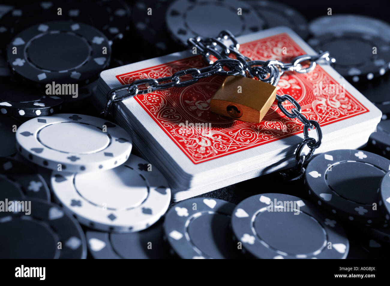 Deck of cards wrapped in chains on gambling chips monochrome image with ...