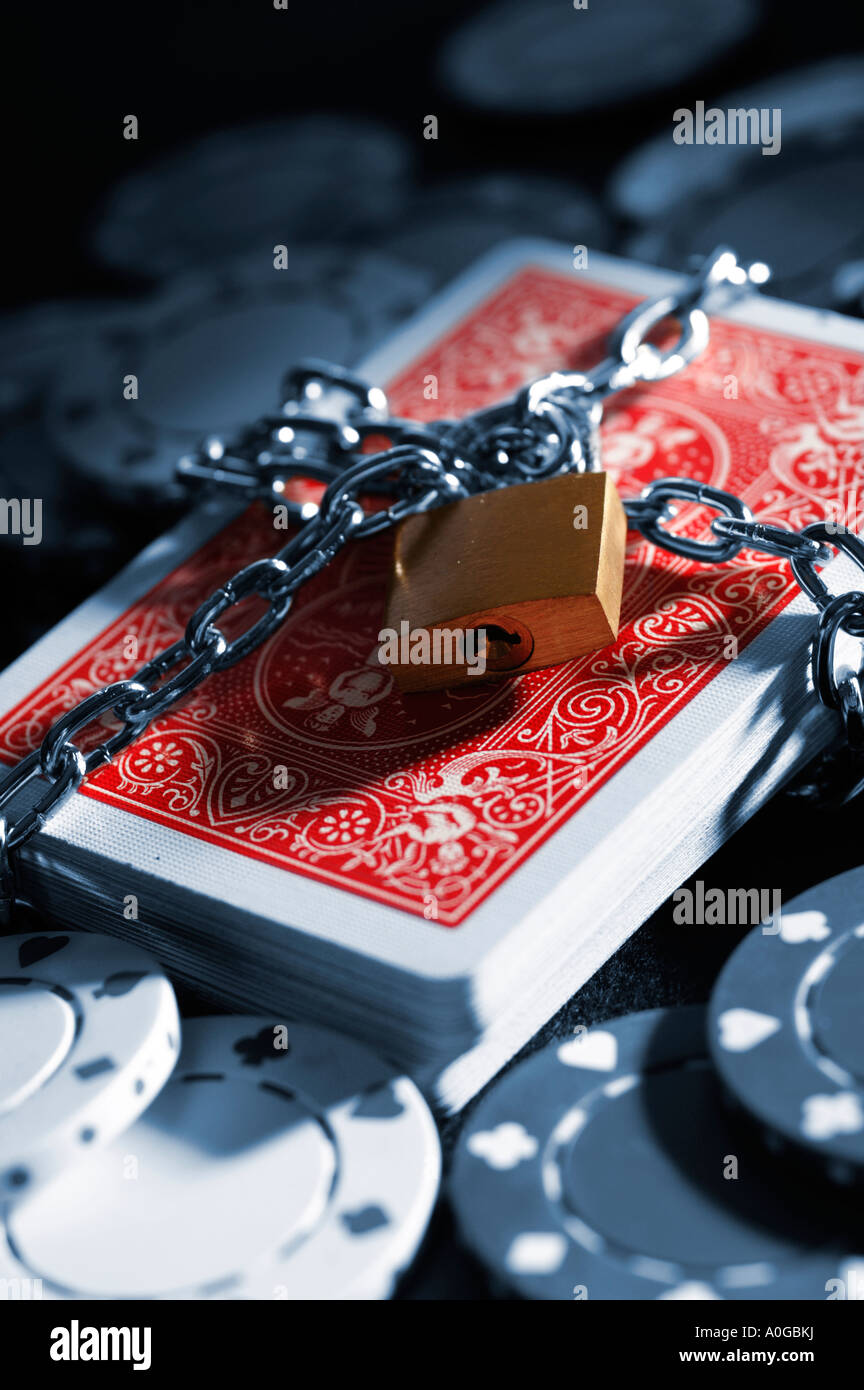 Deck of cards wrapped in chains on gambling chips monochrome image with ...