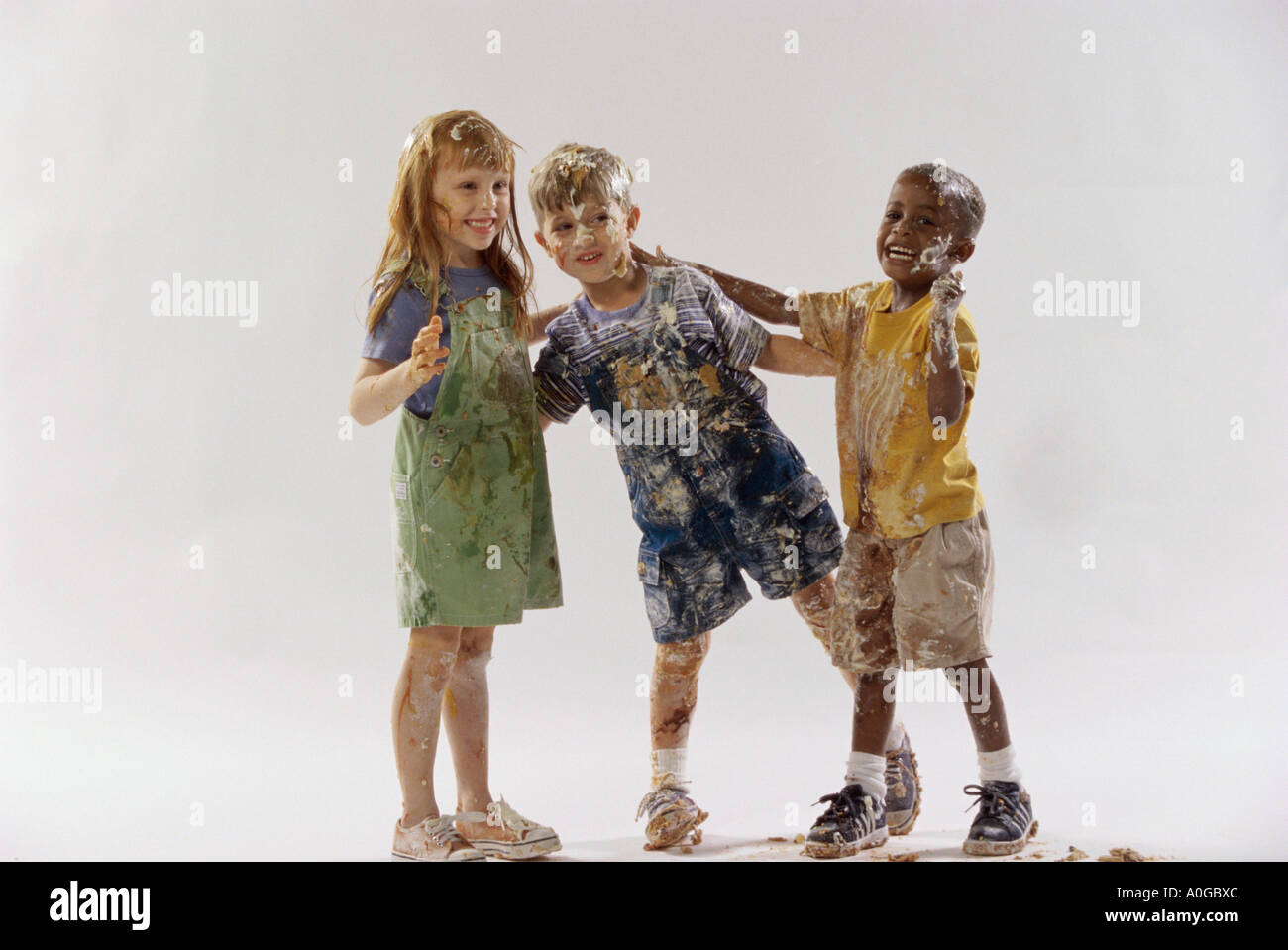 Two boys and a girl having a food fight Stock Photo - Alamy