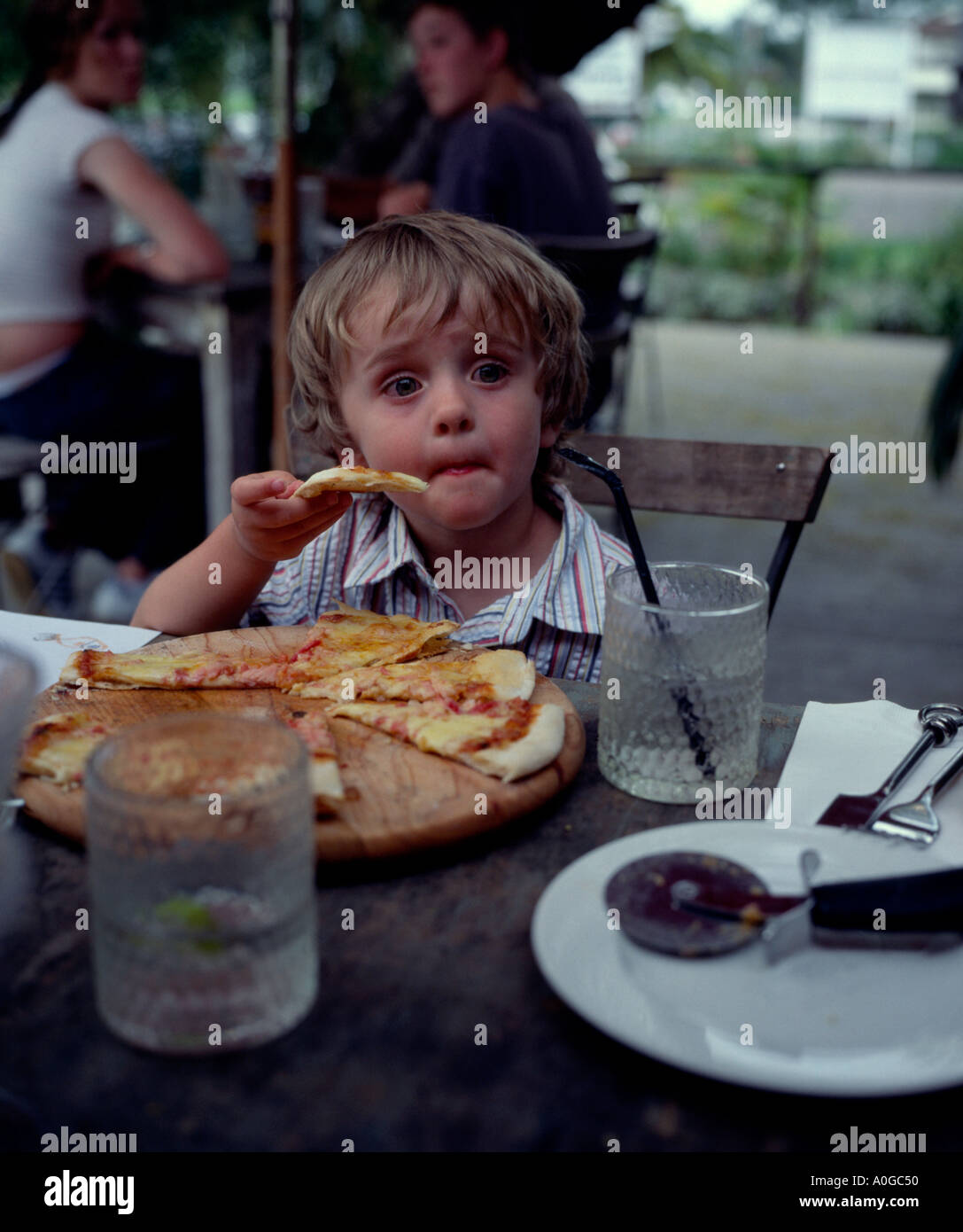 boy child eating pizza alfresco cafe resturant Stock Photo - Alamy