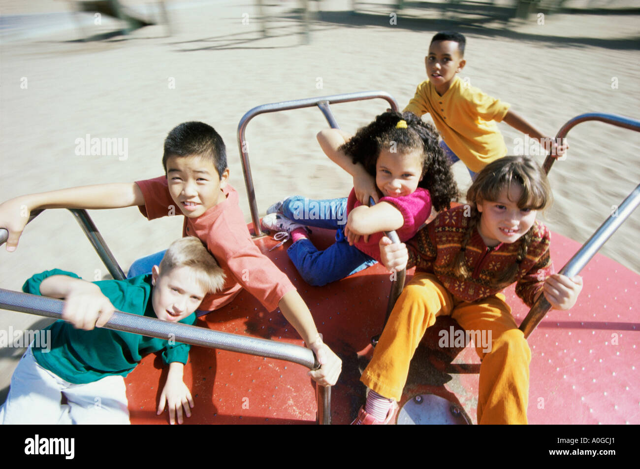 Portrait of a group of children sitting on a merry-go-round Stock Photo ...
