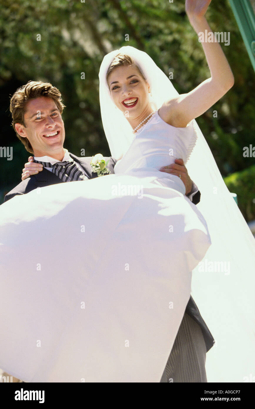 Portrait of a groom lifting his bride Stock Photo - Alamy