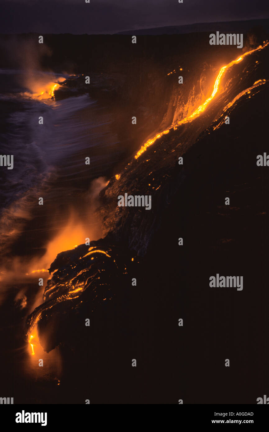Large cascade of lava pouring over the sea cliff at sunrise Volcanoes ...