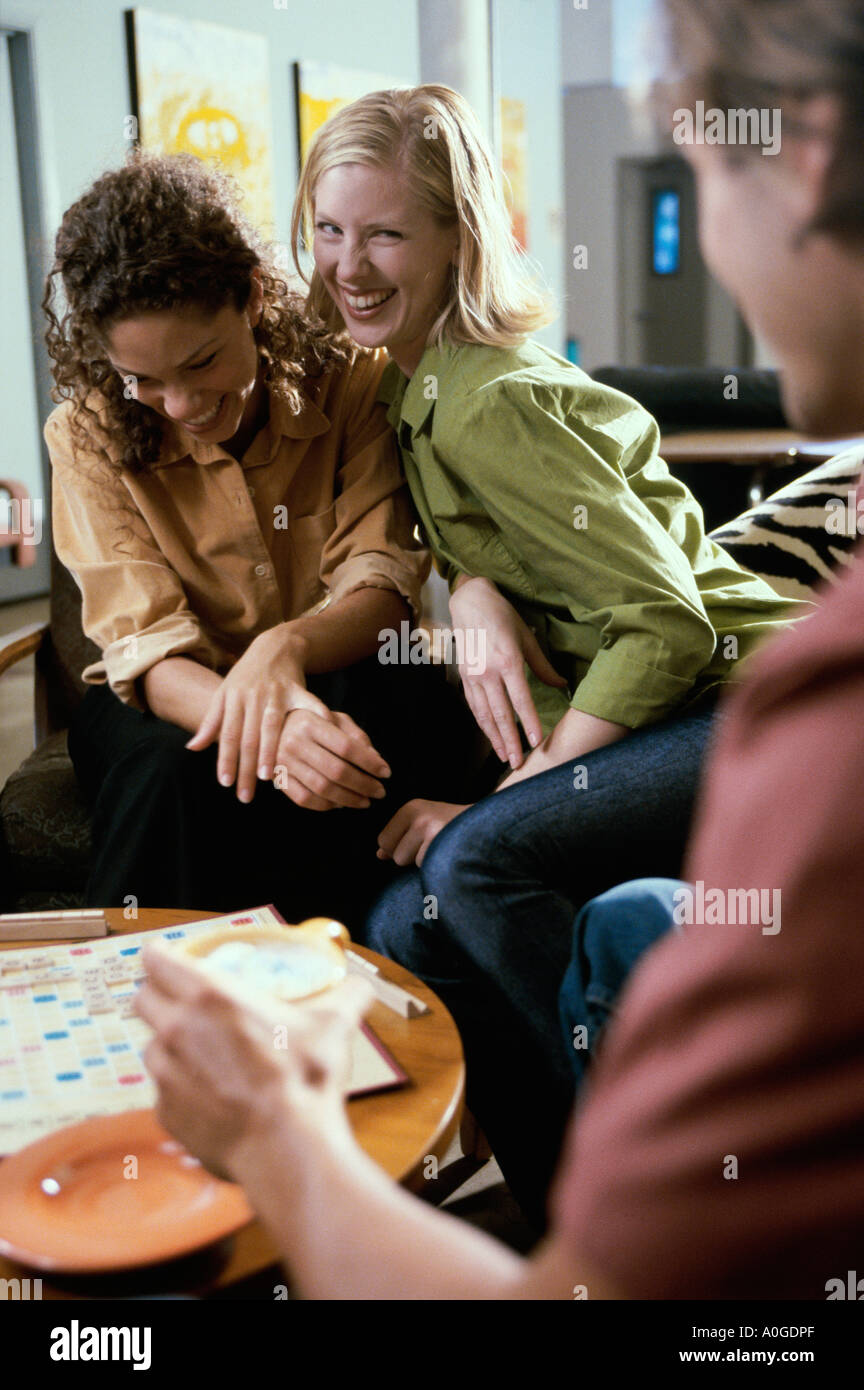Two young women and a young man playing scrabble Stock Photo - Alamy