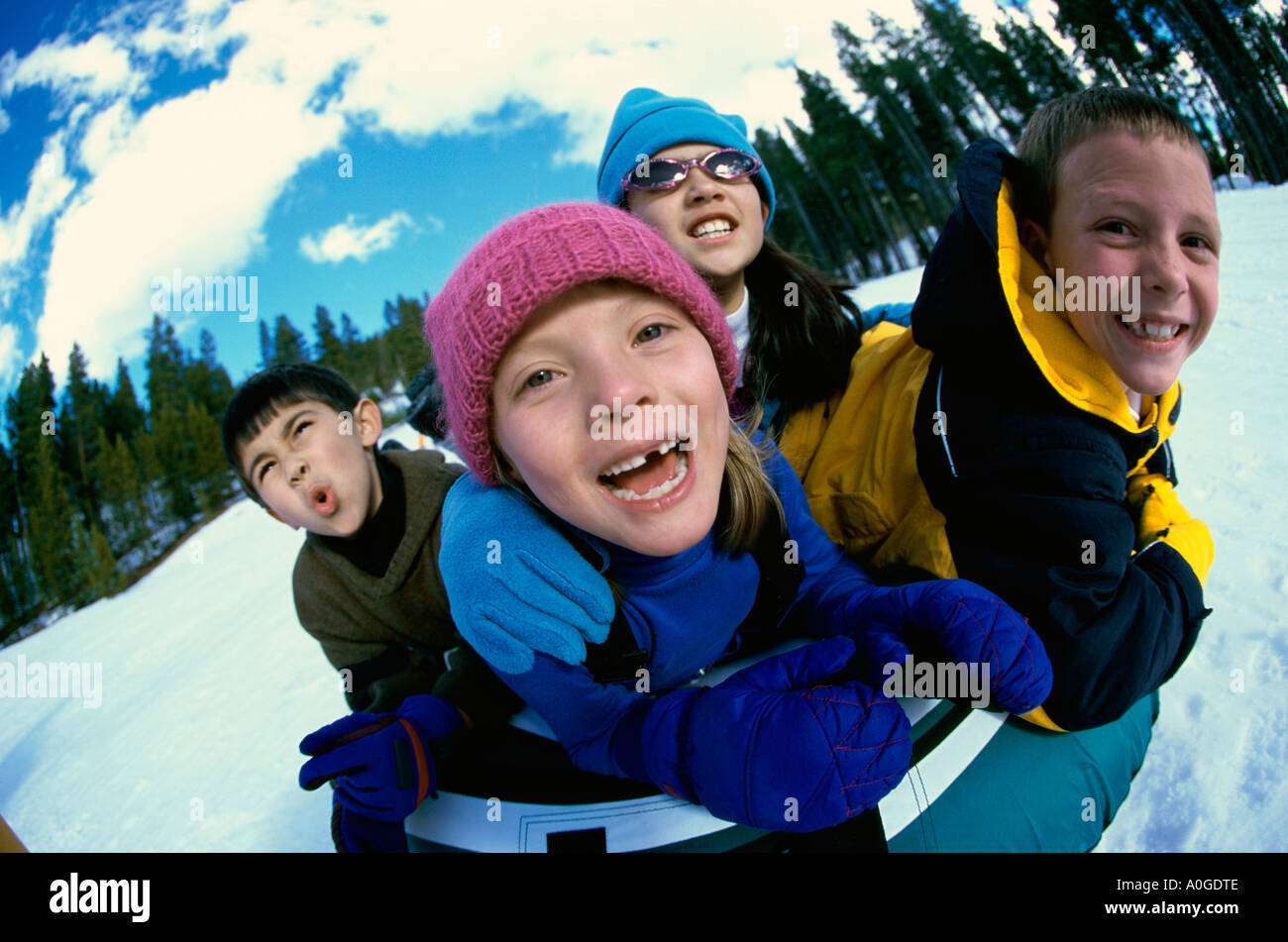 Close-up of two boys and two girls riding on an inflatable ring Stock ...