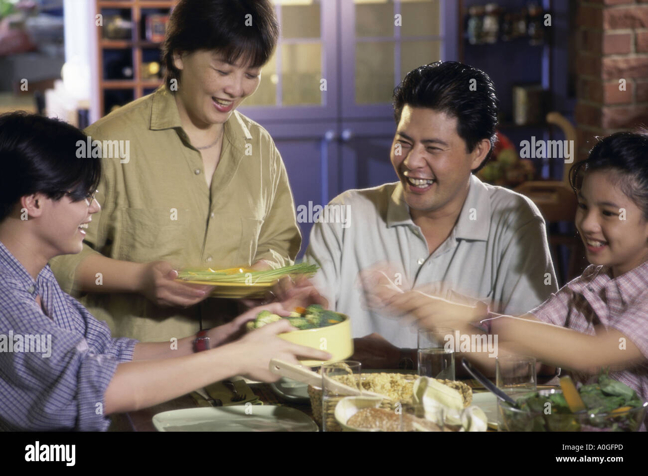 Parents with their children at a dining table Stock Photo - Alamy