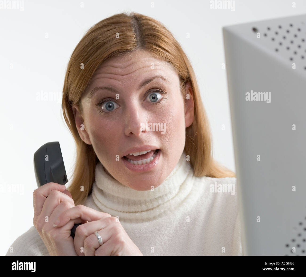 Annoyed woman with phone and computer Stock Photo - Alamy
