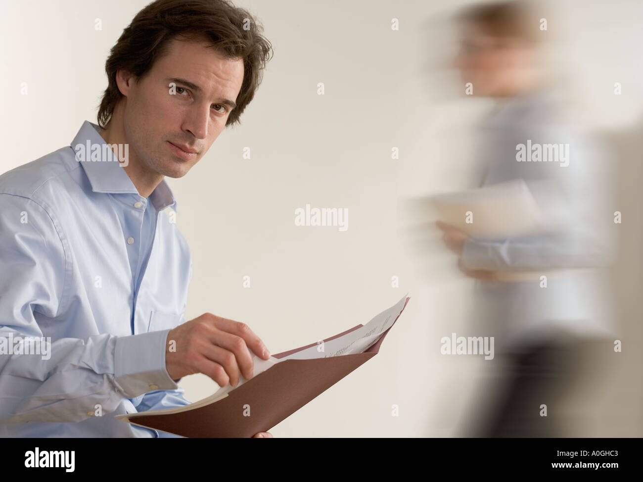 Man holding file with person passing Stock Photo - Alamy