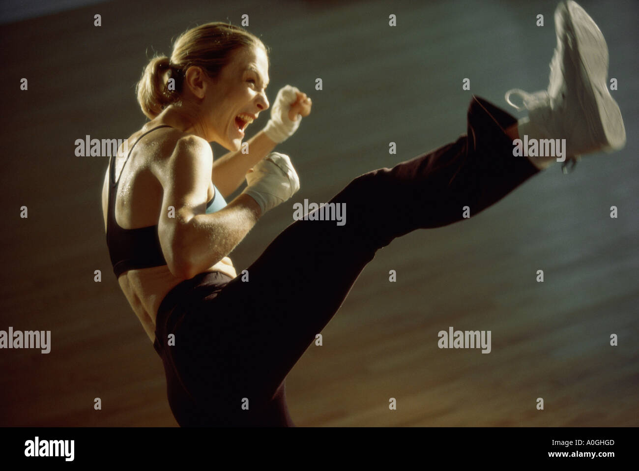 Side profile of a young woman kickboxing Stock Photo - Alamy