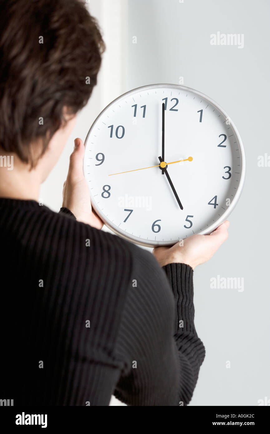Man from behind holding clock Stock Photo - Alamy