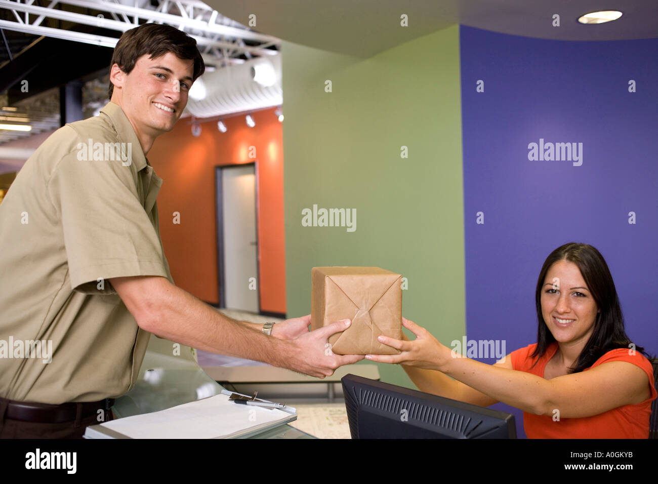 Receptionist receiving package from delivery hi-res stock photography ...