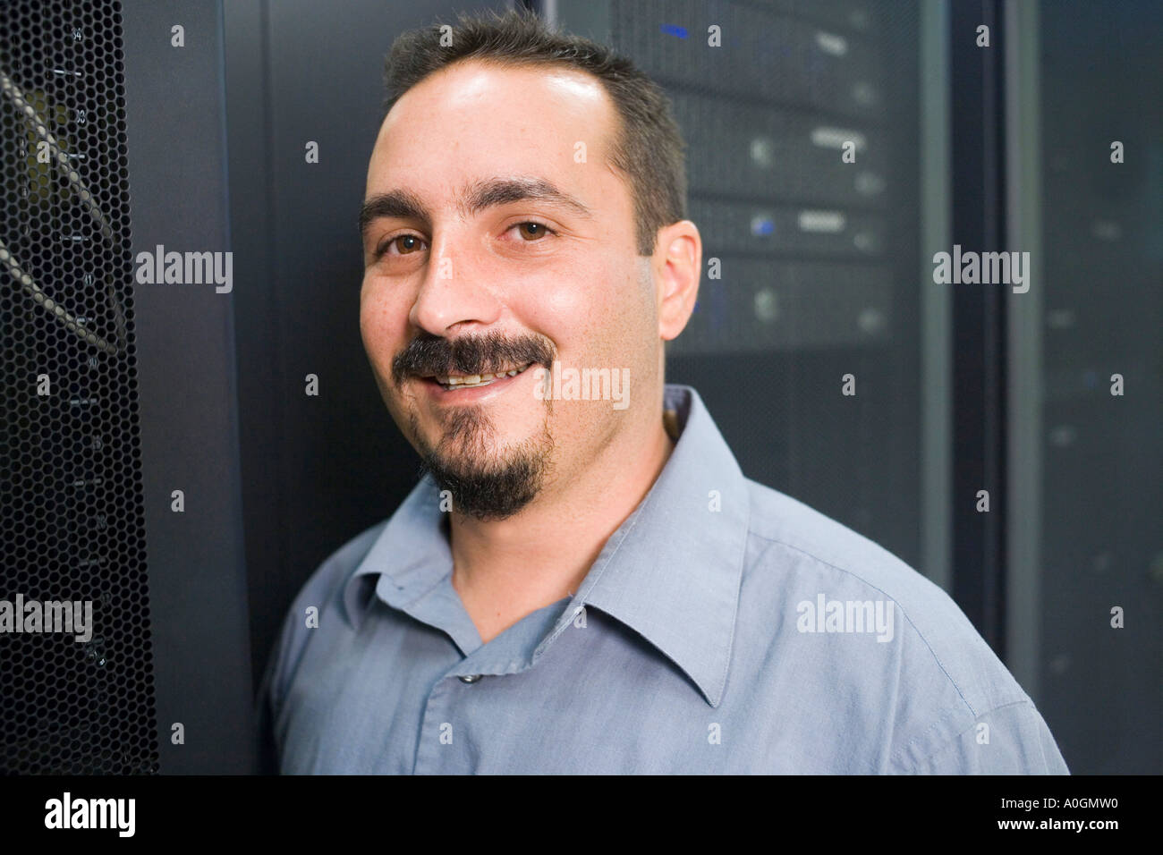 Portrait of a technician smiling in a server room Stock Photo - Alamy