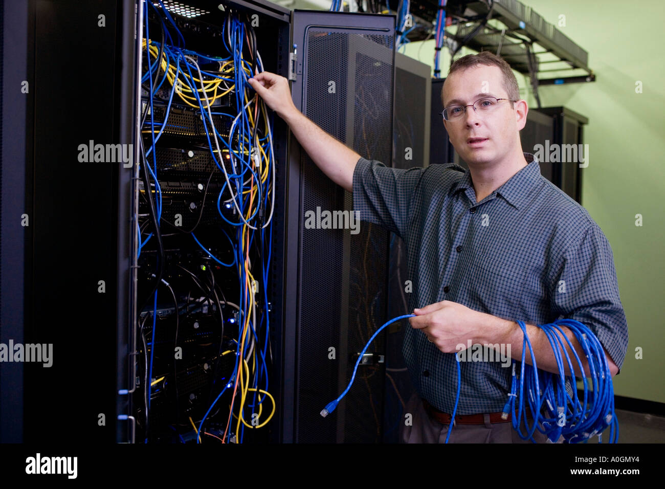 Portrait of a technician with computer cables in a server room Stock ...