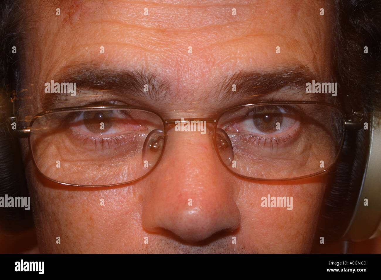 A VERY CLOSE PHOTO OF A MANS FACE WEARING GLASSES LOOKING SLIGHTLY ...
