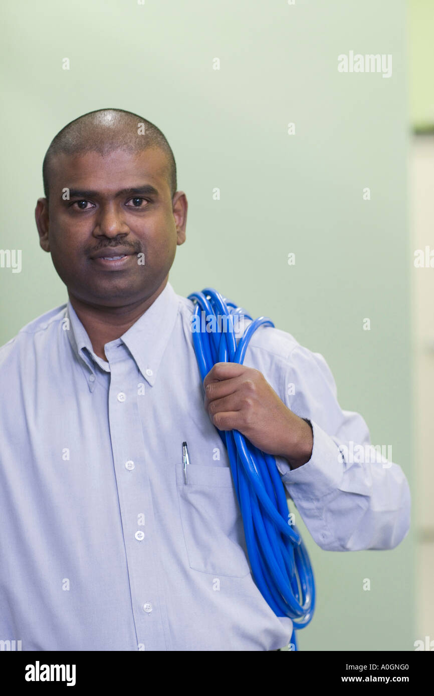 Portrait of a technician carrying computer cables on his shoulder Stock ...