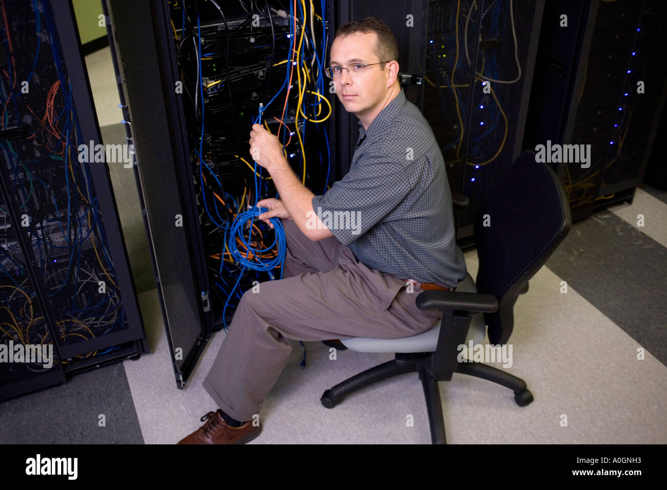 Portrait of a technician with computer cables in a server room Stock ...